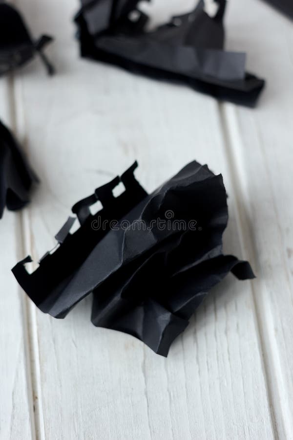 Crumpled Piece of Black Paper on a White Table Stock Image - Image of ...