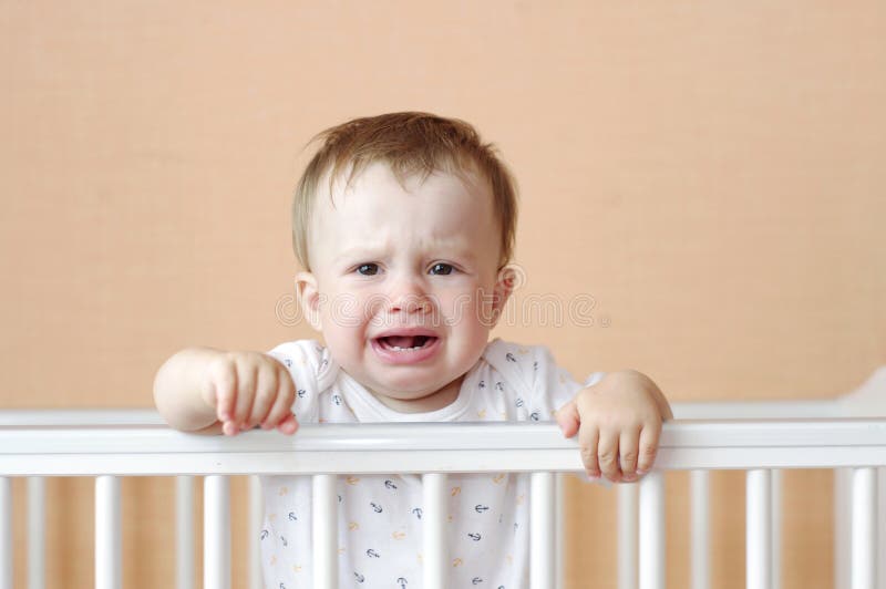 Crying baby in white bed stock photo. Image of whimsical - 33871124
