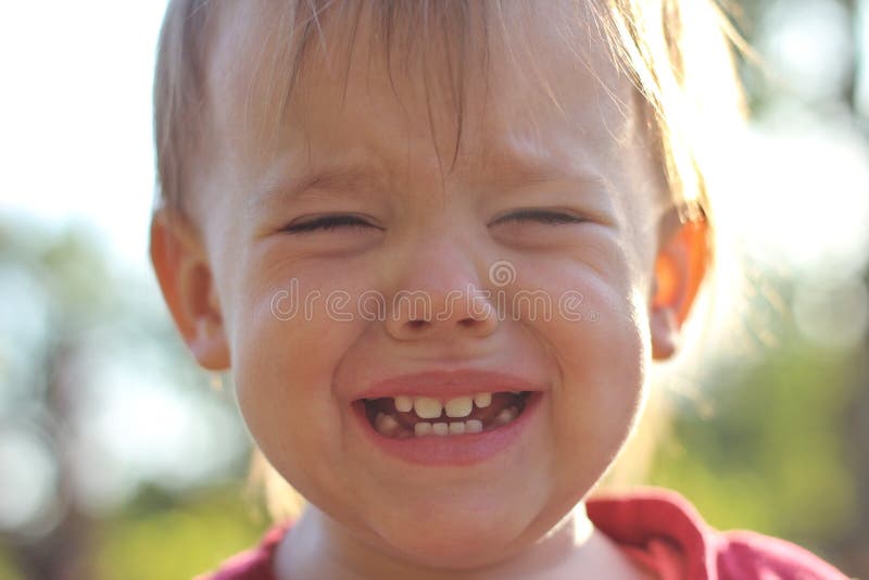 Crying White Baby with White Teeth and Blurry Summer Background Stock ...