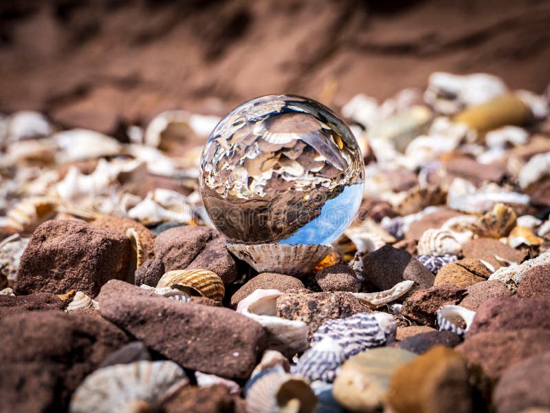 Crystal Ball on Rocky Beach with Shells and Sky Reflection. Stock Photo ...