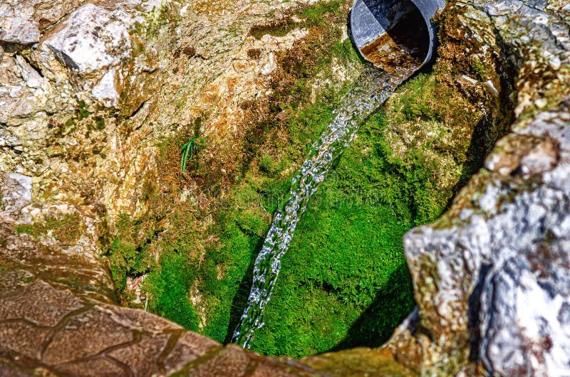Crystal Clear Spring Water Flows from Iron Pipe among Stones with Green ...