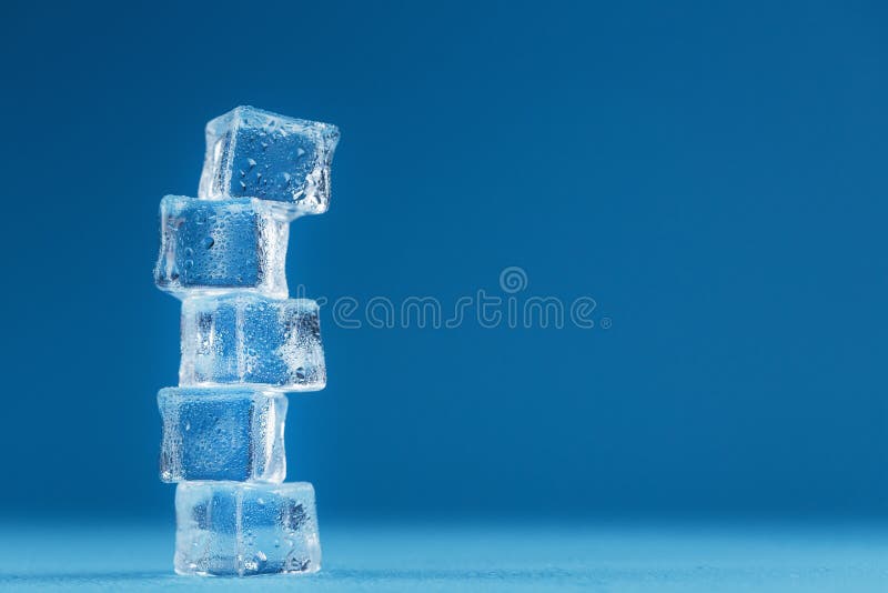 Cubes of Melting Ice Tower on a Blue Background. Stock Photo - Image of ...