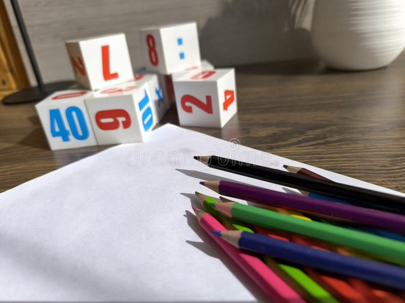 Cubes with Numbers, Pencils and a White Sheet of Paper on the Table ...