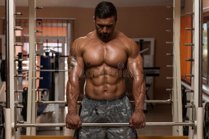 Culturista Que Hace Ejercicio Del Trapecio Imagen de archivo - Imagen ...