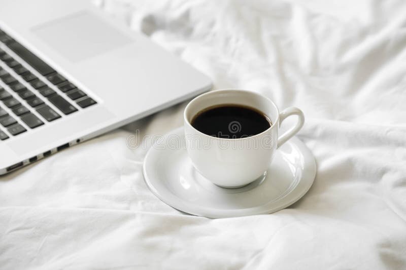 Cup of Black Coffee, Laptop and Smartphone on Unmade White Bed. Stock ...