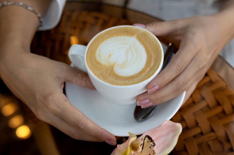 A Cup of Cappuccino in a Womans Hands at a Table in a Cafe. Stock Image ...