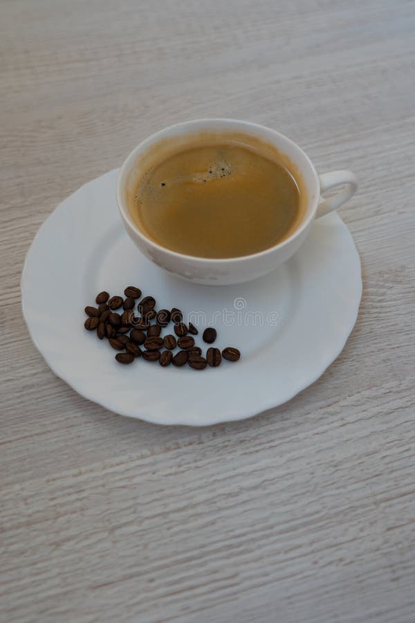 A Cup of Coffee and Coffee Beans on White Plate Stock Image - Image of ...