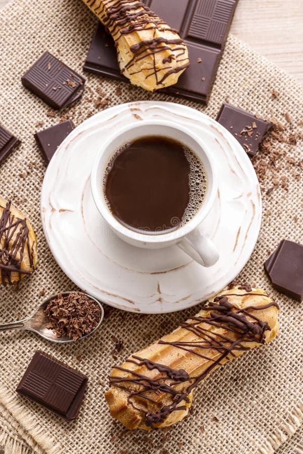 Cup of coffee and eclairs stock photo. Image of eclair - 85726894