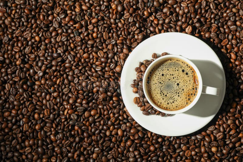 Cup of Coffee with Frothy Foam on Beans Background, Top View and Space ...