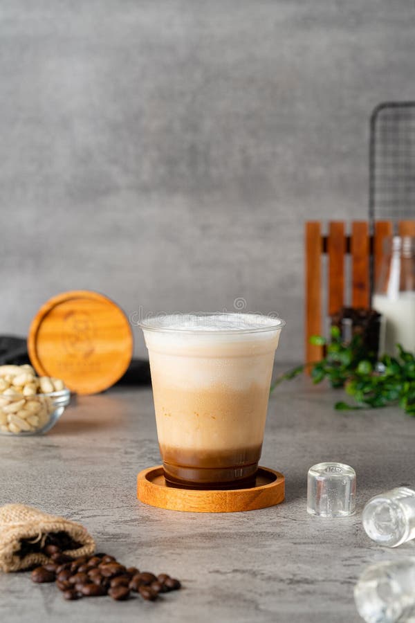 A Cup of Coffee with Milk Layer and Coffee Beans on Side Stock Photo ...