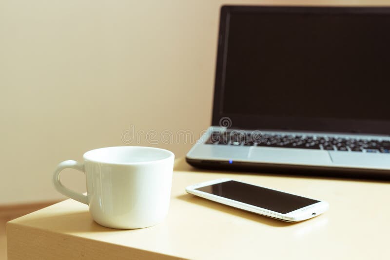 Cup of Coffee, Smartphone and Laptop on the Desk Stock Photo - Image of ...