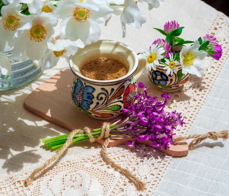 A Cup of Coffee and Spring Wildflowers on a White Tablecloth. Sunlight ...