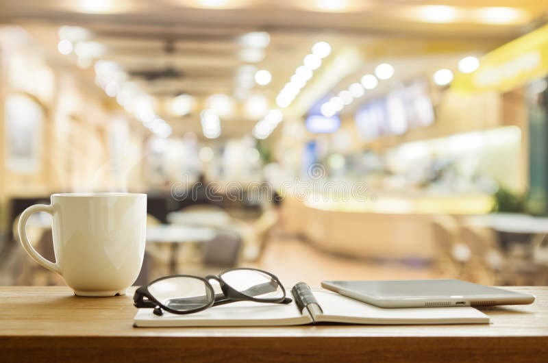 Cup of Coffee and Tablet on Wooden Table in Coffee Shop. Stock Photo ...
