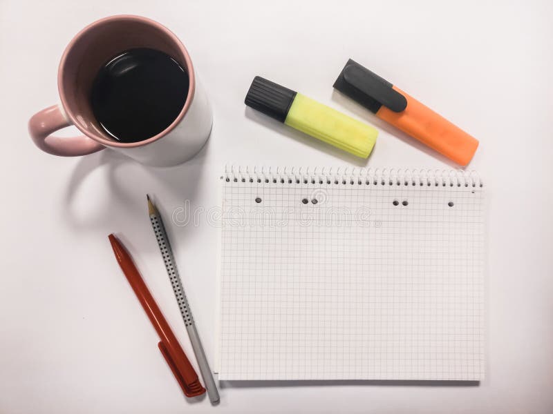 A Cup of Coffee with Two Highlighters and Pens Near a Notebook on a ...