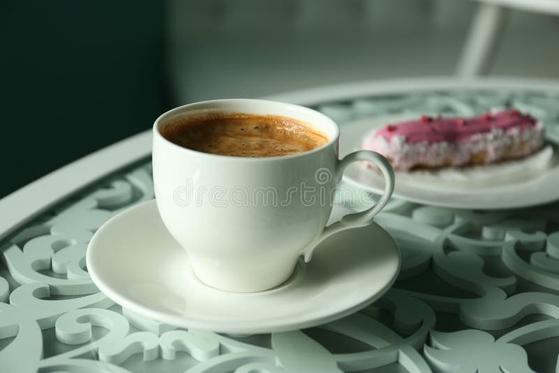 Cup of Delicious Aromatic Coffee and Eclair on Table Indoors Stock ...