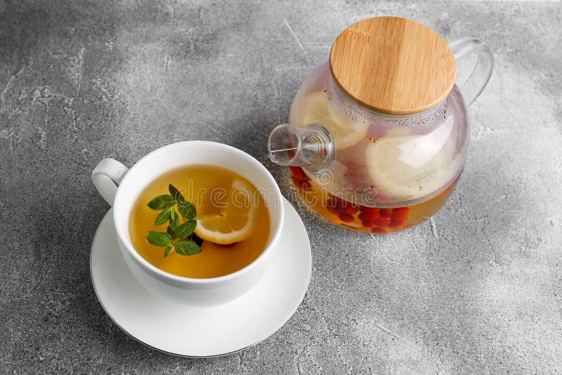 Cup with Delicious Immunity Boosting Tea and Teapot on Grey Table ...