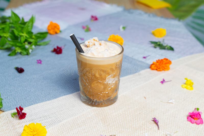 Cup of Iced Coffee Latte with Flowers in the Backdrop on a Table. Stock ...