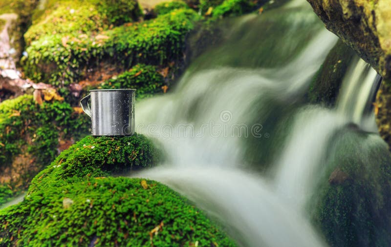 Cup of Pure Water with Drops on the Mountain River with Stones Stock ...