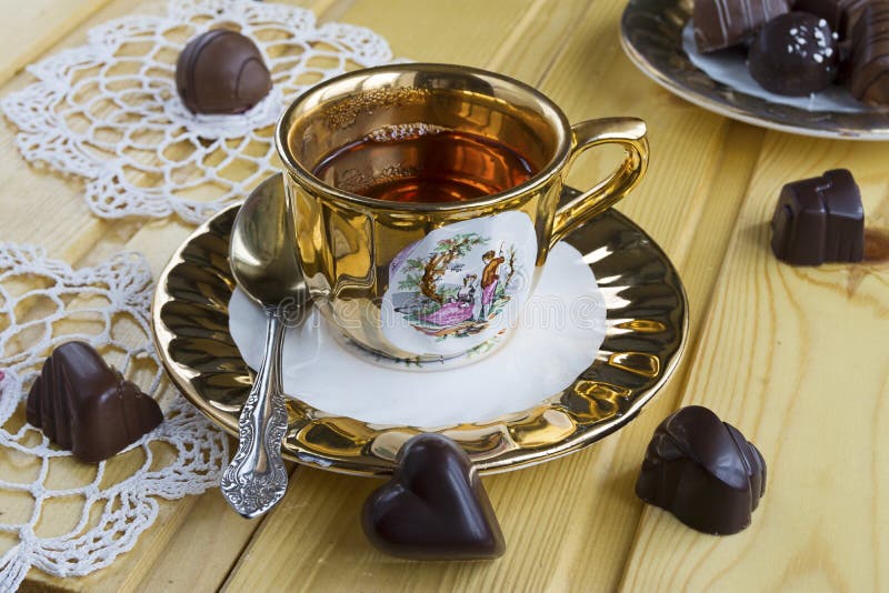 A Cup of Tea with Chocolate Candies on Wooden Table Stock Image - Image ...