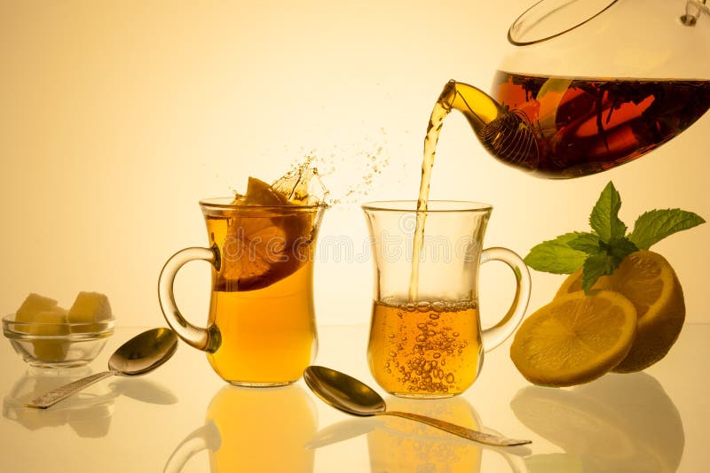 Cup of Tea and Glass Teapot on Glass with Orange Background Stock Photo ...