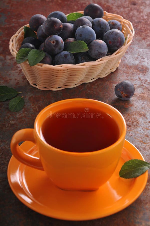 A Cup of Tea and Plum on the Table Stock Photo - Image of golden, life ...