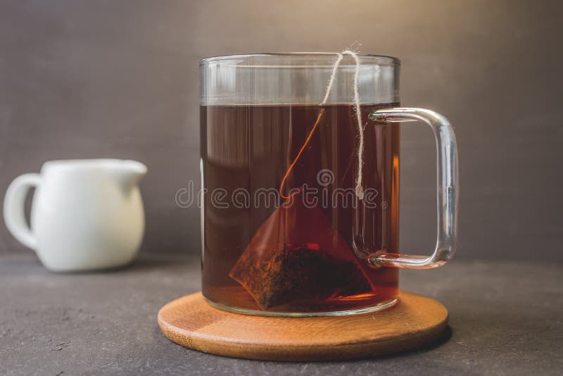 Cup of Tea on Wooden Support and Creamer on Black Table/cup of Tea on ...