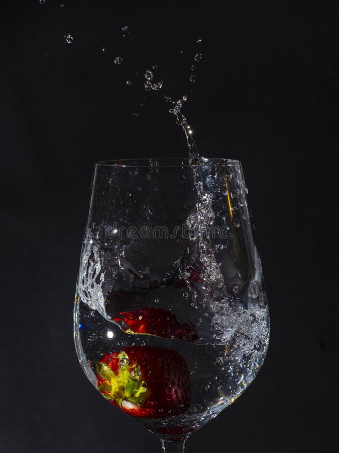 Cup with Water Falling from a Strawberry and Splashing Out of the Cup ...