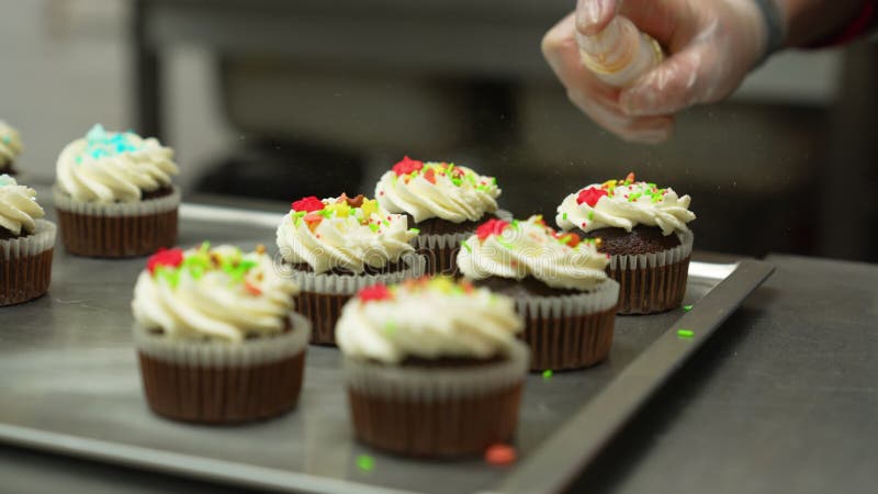 Unrecognisable Baker Piping White Frosting on Chocolate Cupcakes on ...