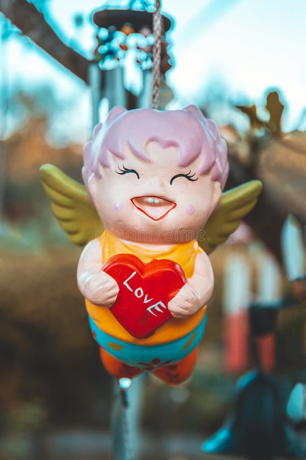 Cupid Clay Doll Hanging in the Tree of Garden. Stock Photo - Image of ...