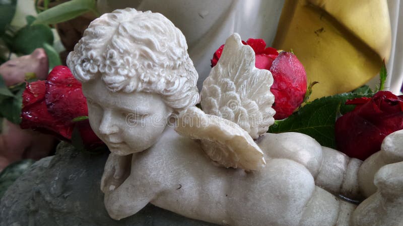 Cupid in the garden stock photo. Image of sculpture, flower - 50357354