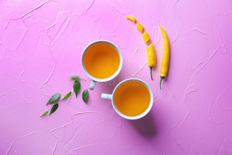 Cups of Hot Aromatic Tea with Yellow Chili Pepper on Table Stock Photo ...