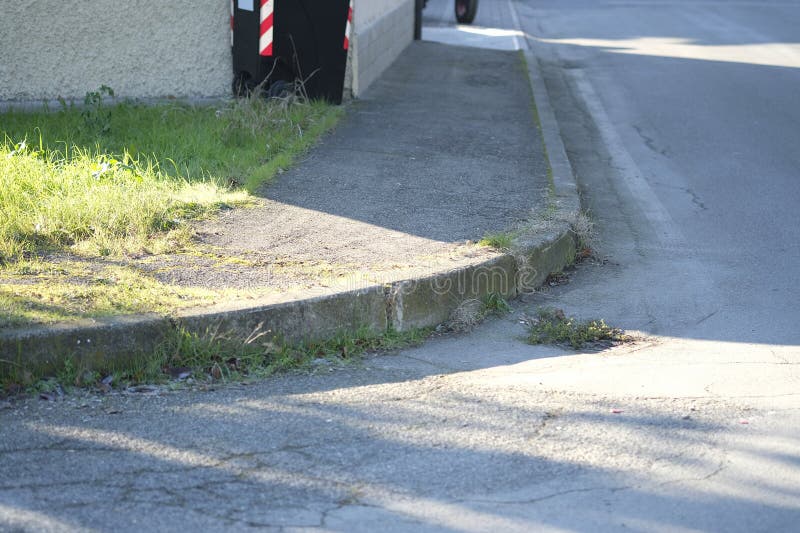 A Curb on the Side of a Road with Grass Growing on it Stock Photo ...