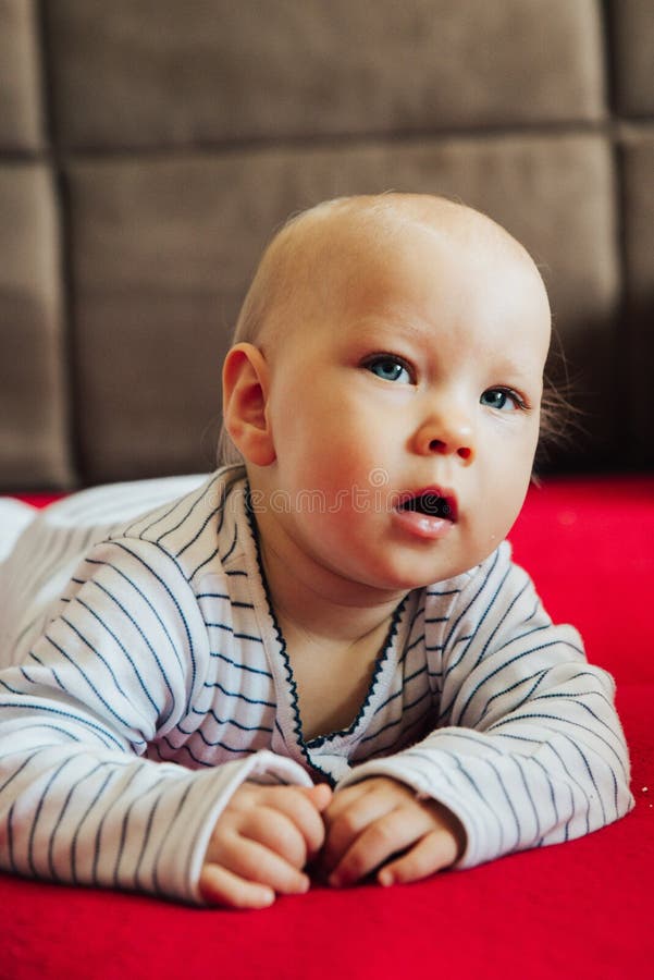 Curious Baby Girl Lying on Bed Stock Photo - Image of holding, bear ...