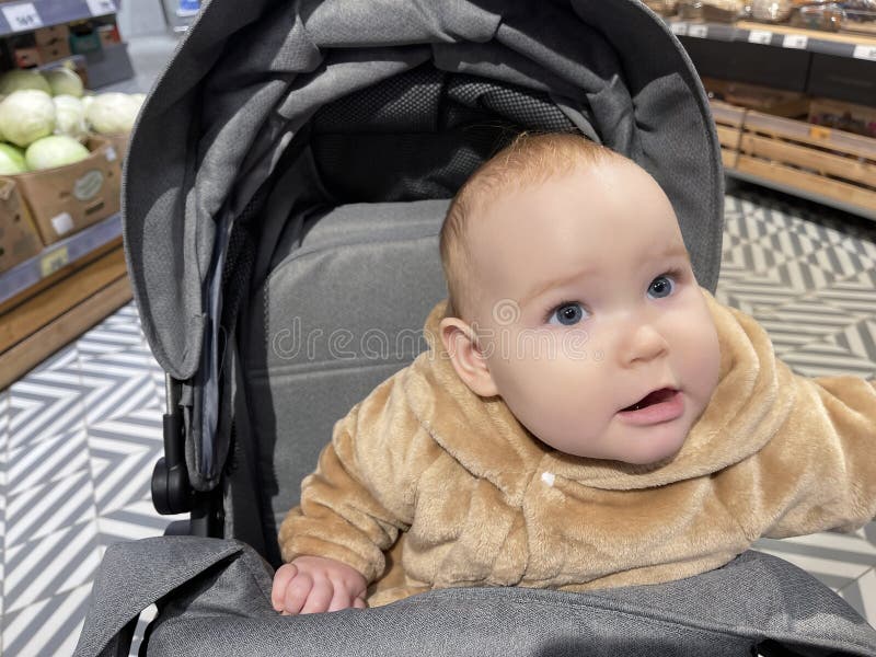 Curious Baby in a Stroller in Supermarket Stock Photo - Image of seated ...