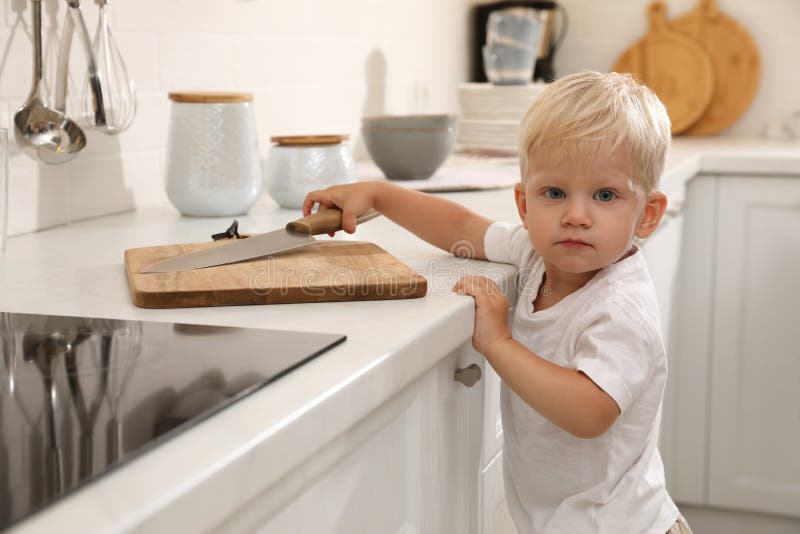 Curious Little Boy Taking Sharp Knife from Kitchen Counter Stock Photo ...