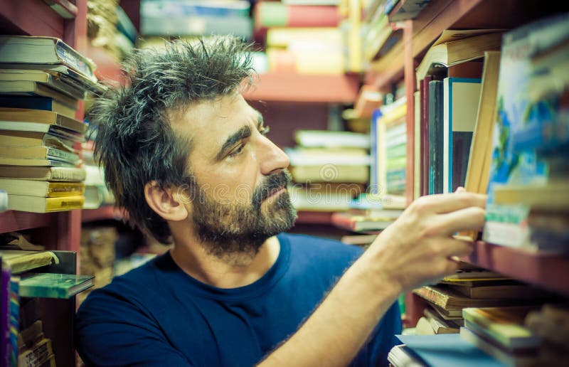 Curious Man Choosing Book between the Shelves in the Library Stock ...