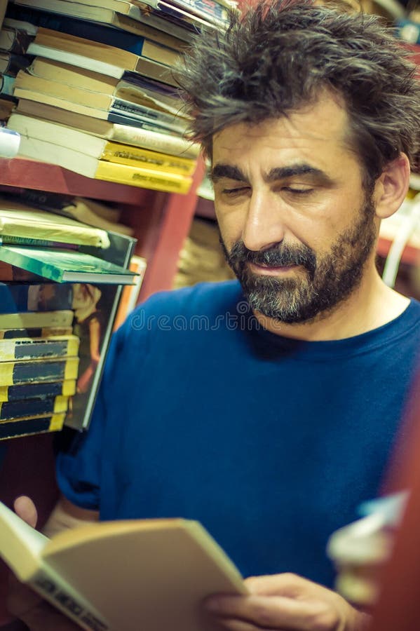 Curious Man Reading Book between the Shelves in the Library Stock Image ...