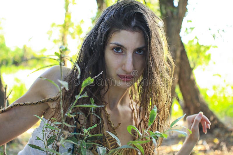Curious Pagan Girl Looking through the Branches into the Camera Stock ...