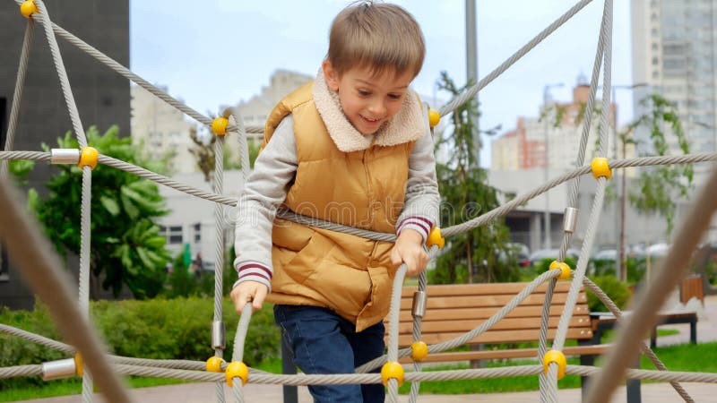 Curious Smiling Boy Climbing and Crawling through Ropes and Spider Web ...