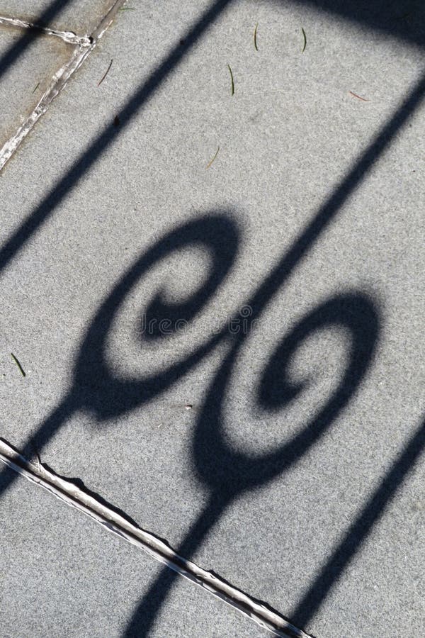Curled Wrought Iron Shadow on Concrete Stock Image - Image of gray ...