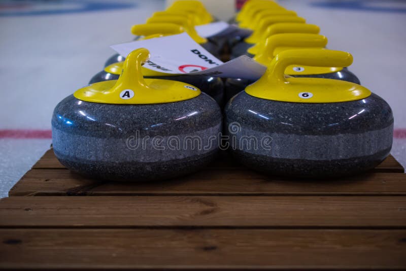 Curling Stones with a Yellow Handle Sit on a Wooden Base Stock Image ...