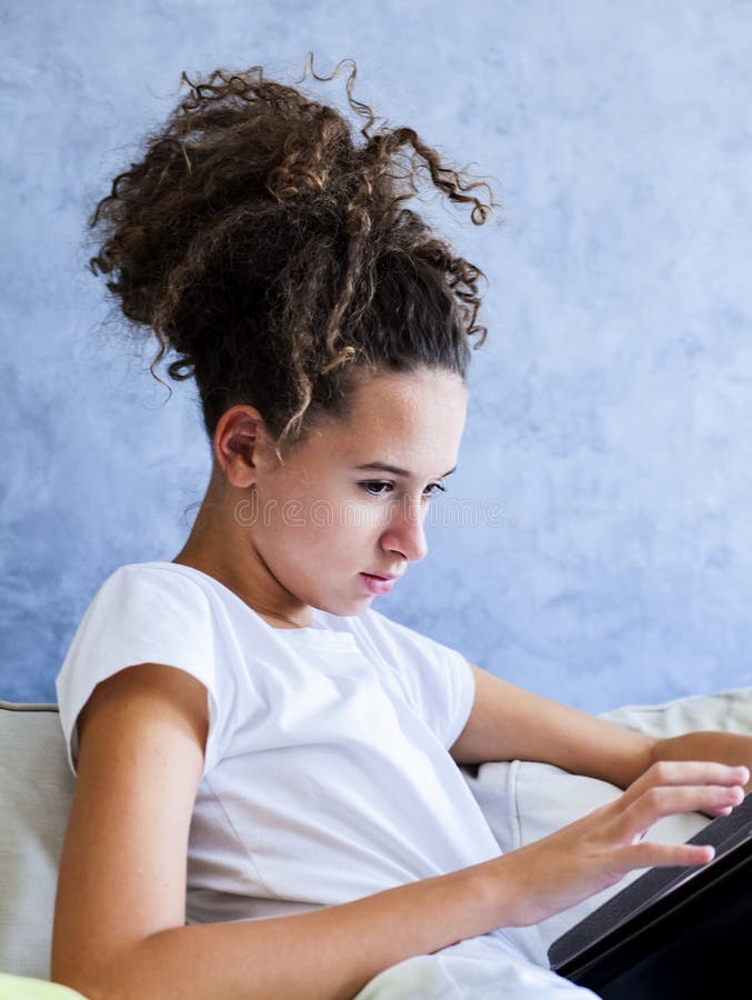 Curly Hair Girl Using Digital Tablet on Sofa Stock Image - Image of ...