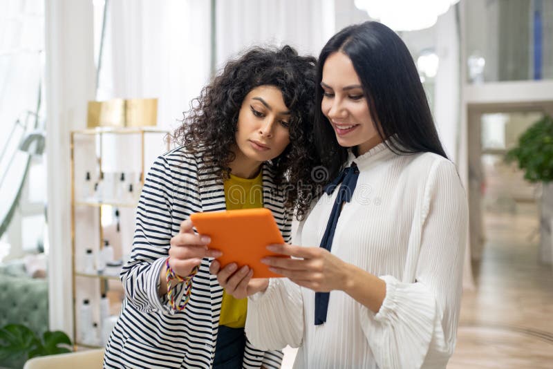 Curly-haired Beautiful Customer in a Striped Jacket Looking Interested ...