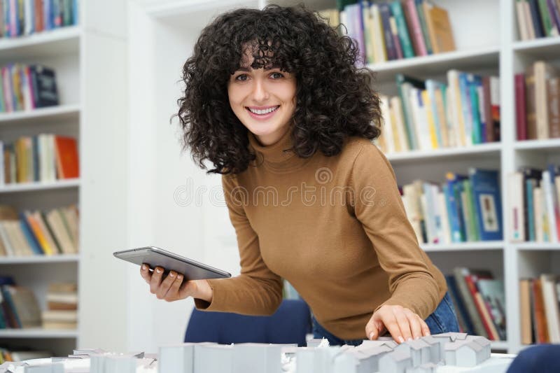 Curly-haired Woman Working on Miniature Project in a Library Stock ...