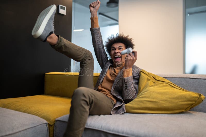 Curly-haired Young Man Looking Excited while Playing Video Games during ...