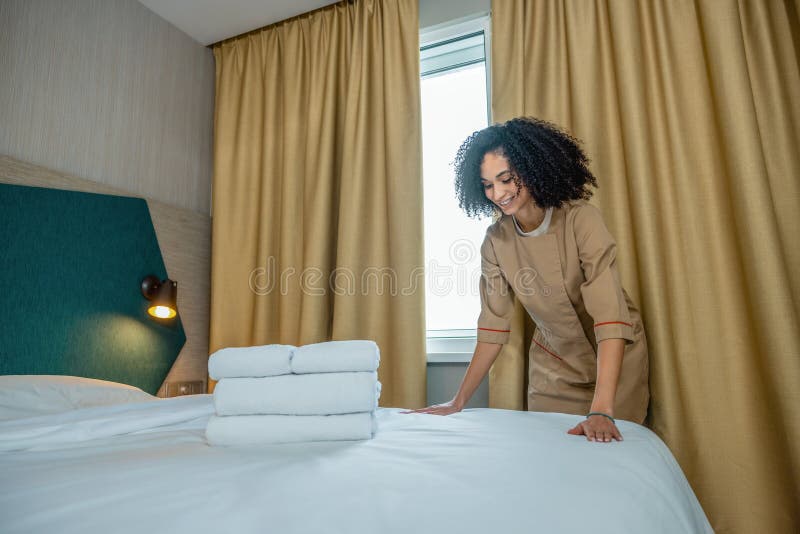 Curly-haired Young Woman Making Bed on a Hotel Room Stock Photo - Image ...