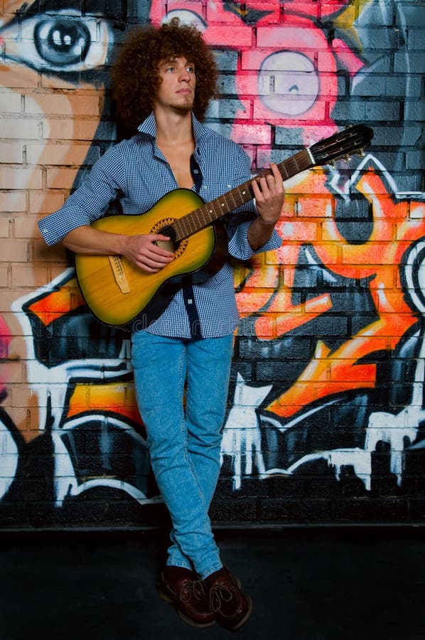 Curly men with a guitar stock image. Image of young, jeans - 16233931