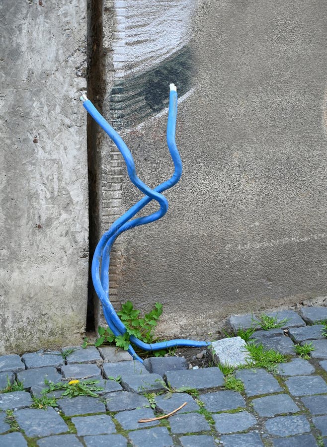 Curved Blue Tube Emerges from a Wall and Interacts with Cobblestone ...