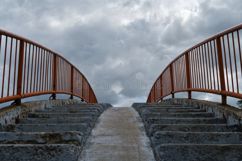Curved Concrete Pedestrian Arch Bridge with Red Iron Railings with ...