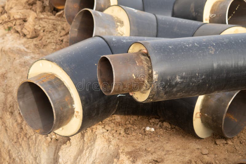 Curved Pipes with Thermal Insulation Stacked at a Construction Site at ...